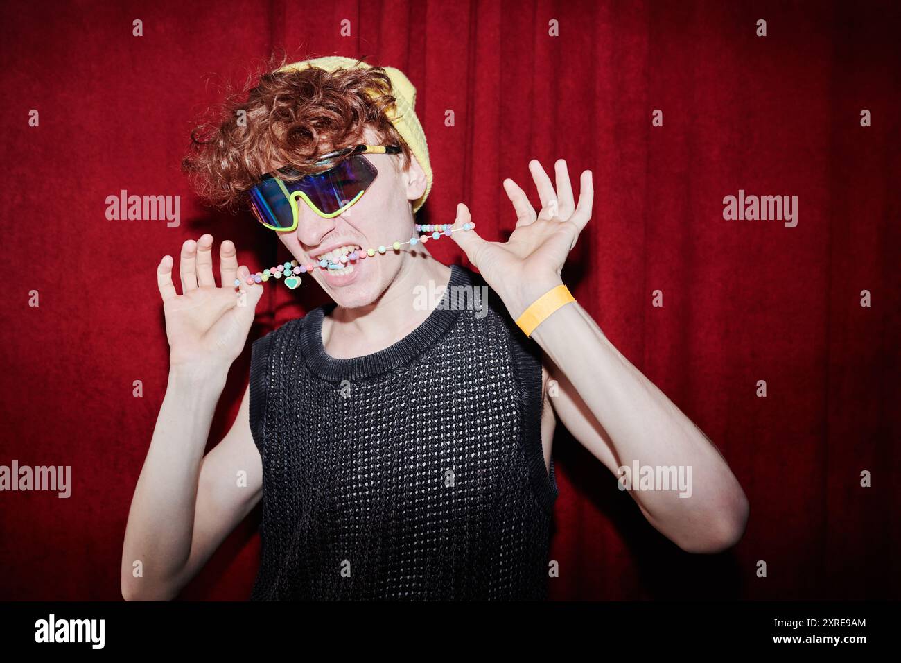 Young stylish man in funky attire standing in front of camera in night ...