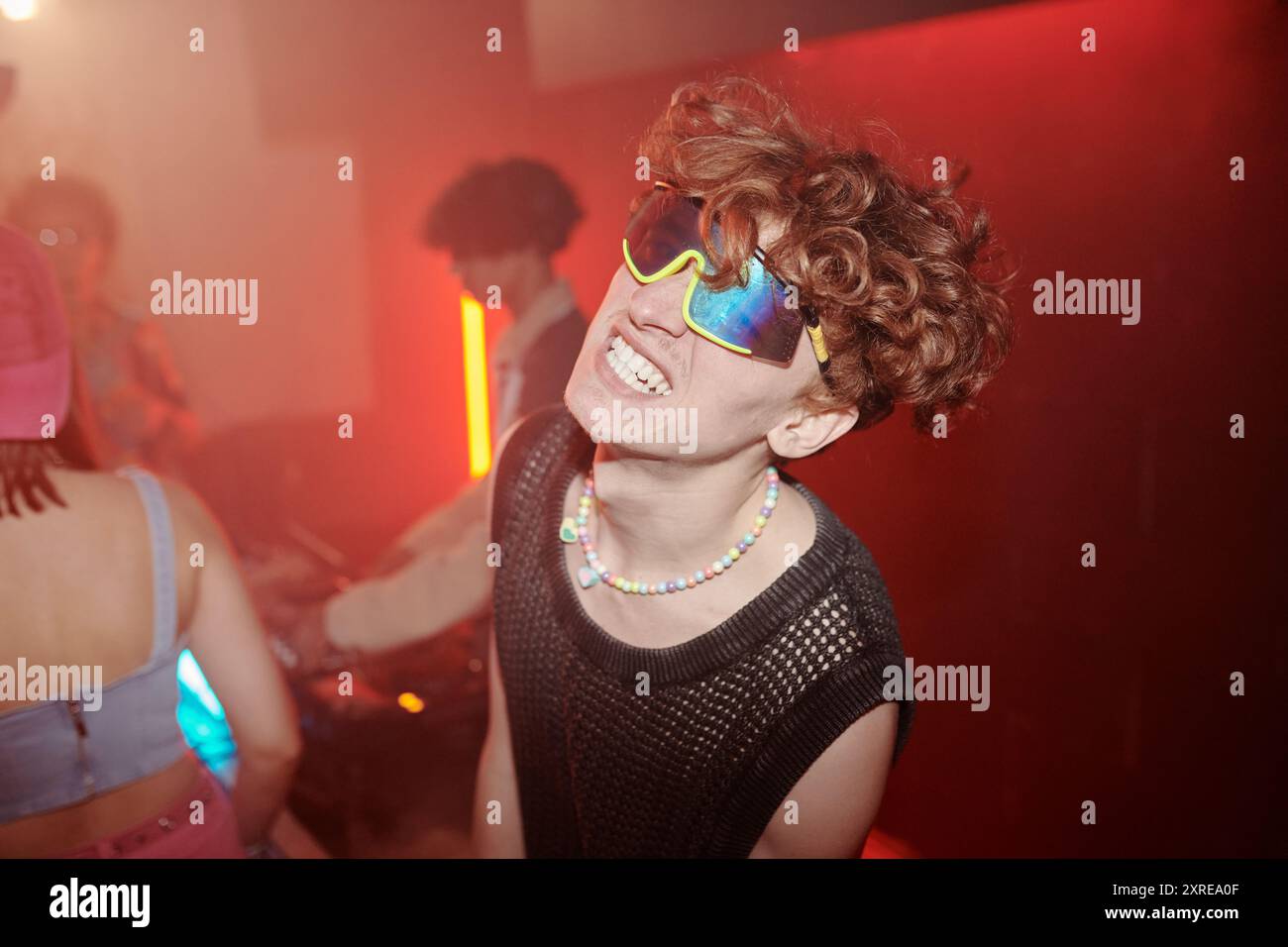 Excited guy in funky attire and stylish sunglasses keeping his teeth ...