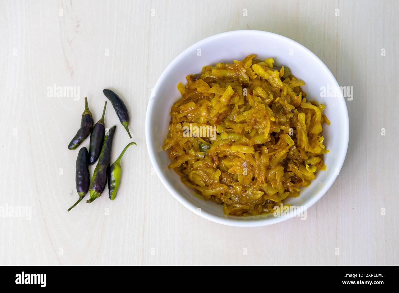 Tasty aloo bhaji in a white bowl on wooden background. Alu bhaja is a ...