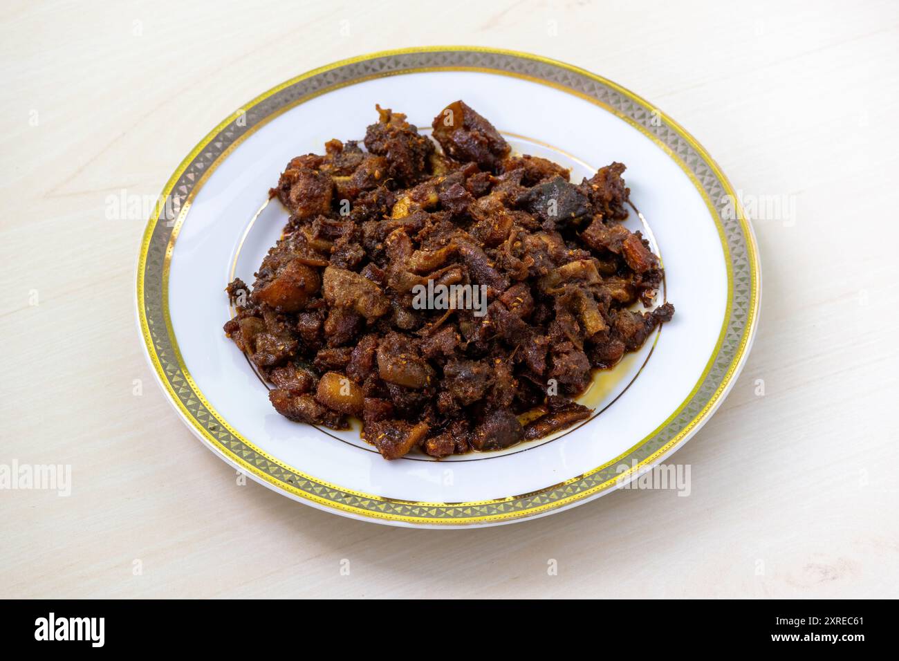 Gorur bot bhaja or gorur vuri bhuna in a white plate on wooden ...