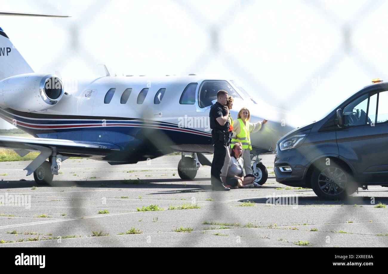 Schleswig-Holstein. August 10, 2024. A Last Generation activist sits ...