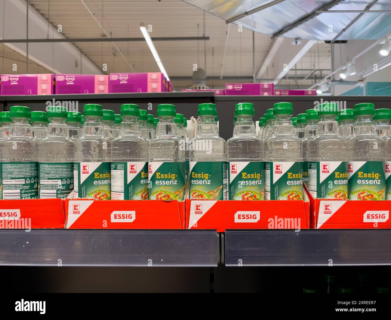 There is a row of green bottles of vinegar on the shelf. All bottles ...