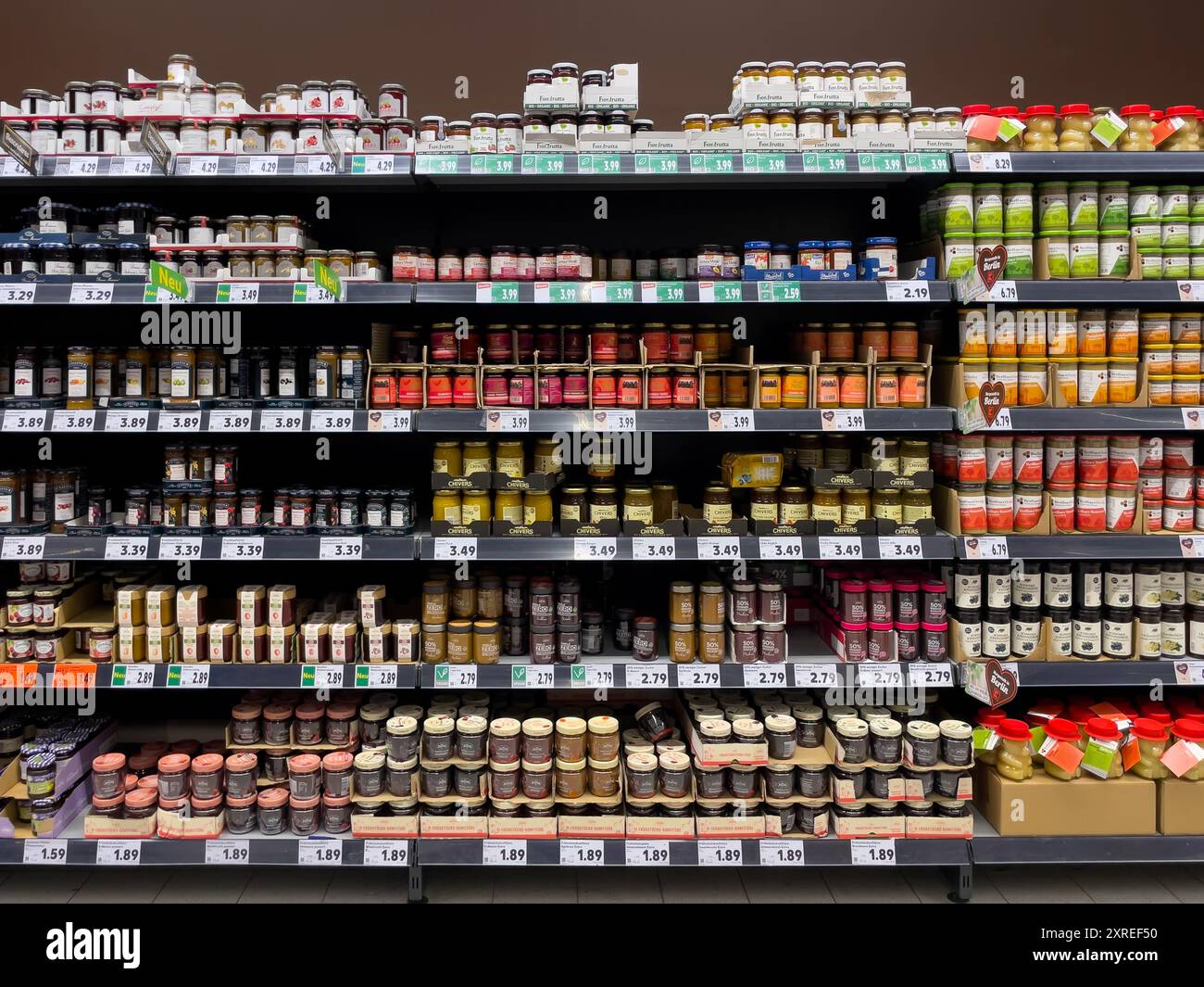 A store shelf with many jars of jam. The shelves in the supermarket are ...