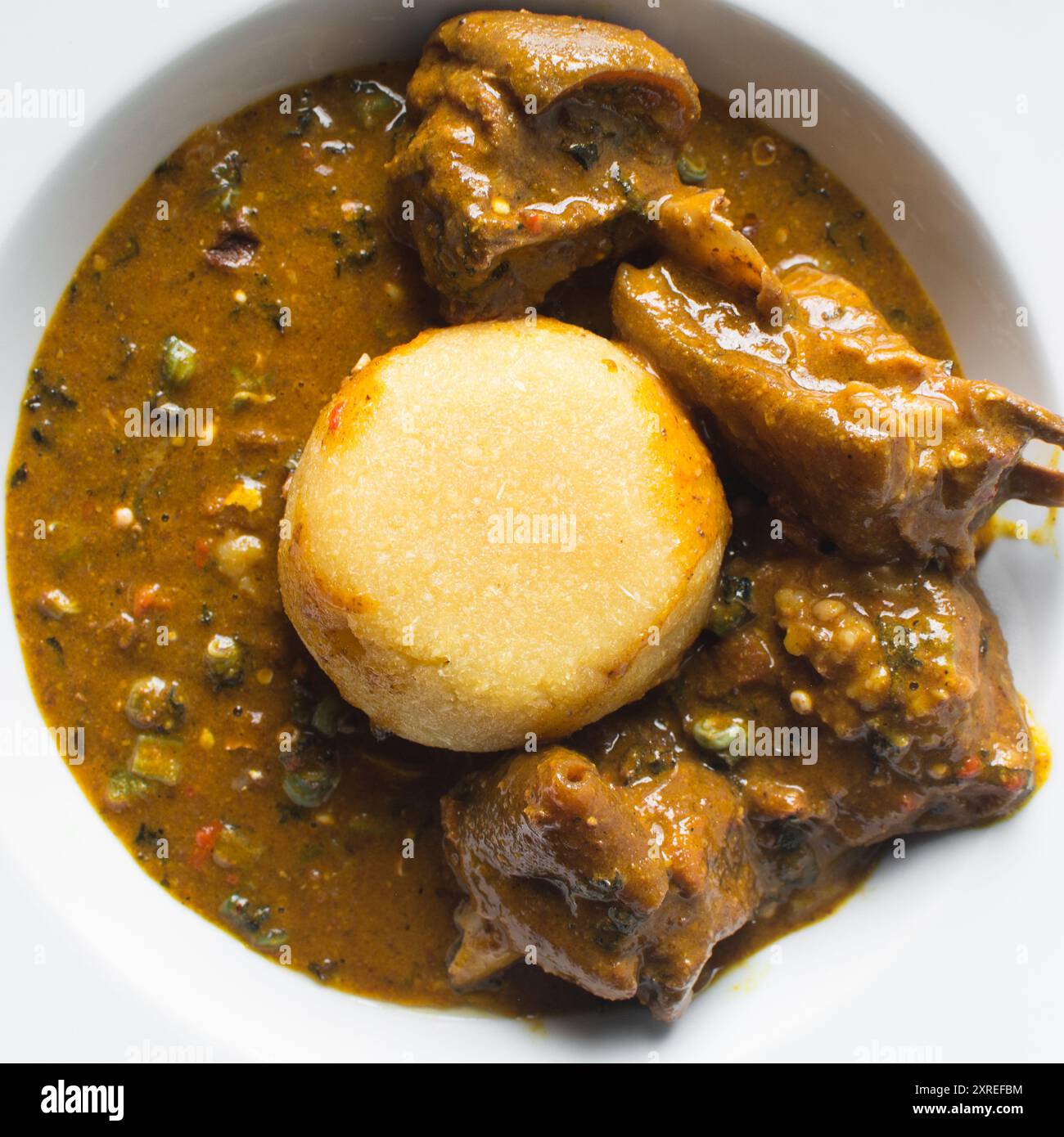 Overhead view of nigerian ogbono soup and eba on a white plate, top ...