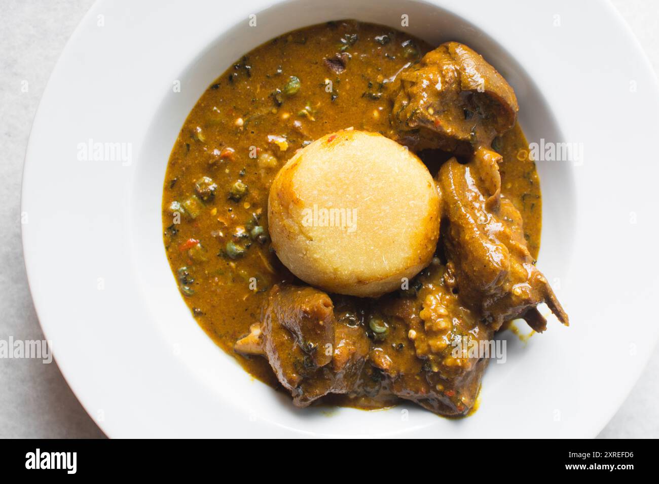 Overhead view of nigerian ogbono soup and eba on a white plate, top ...