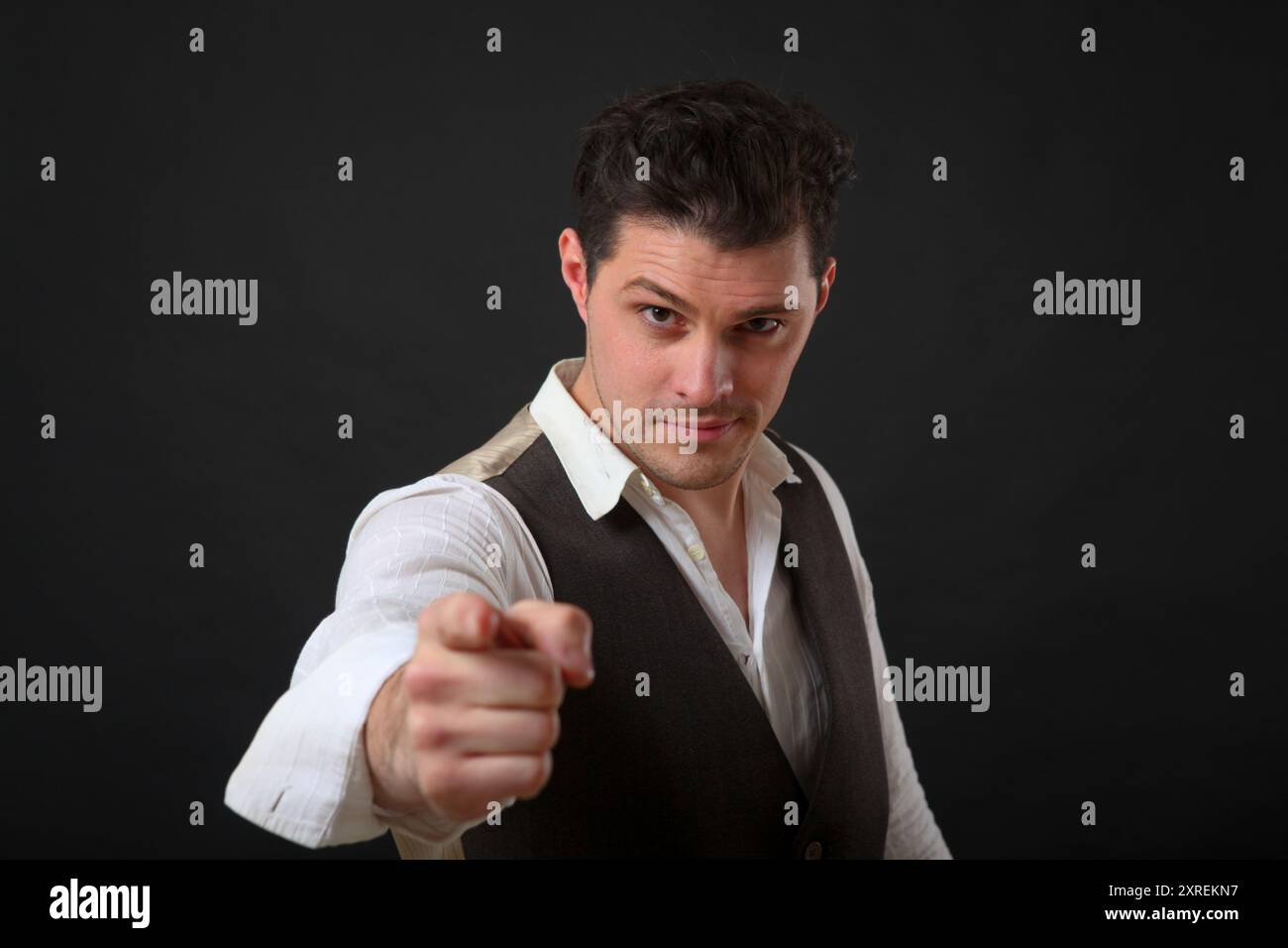portrait of a young man pointing finger on the black background Stock ...