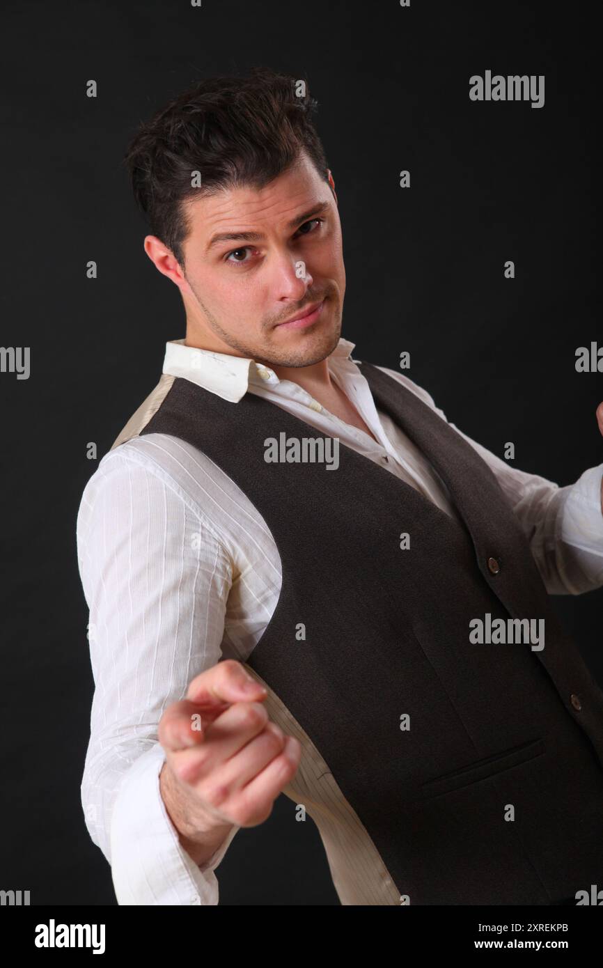 portrait of a young man pointing finger on the black background Stock ...
