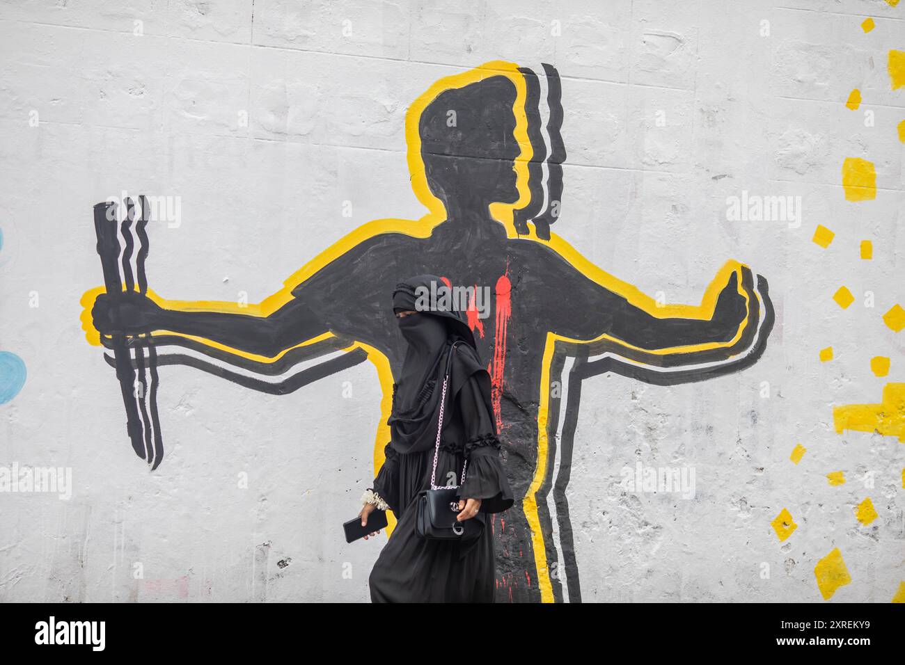 A woman walks past graffiti artwork in Dhaka. Nobel laureate Muhammad ...