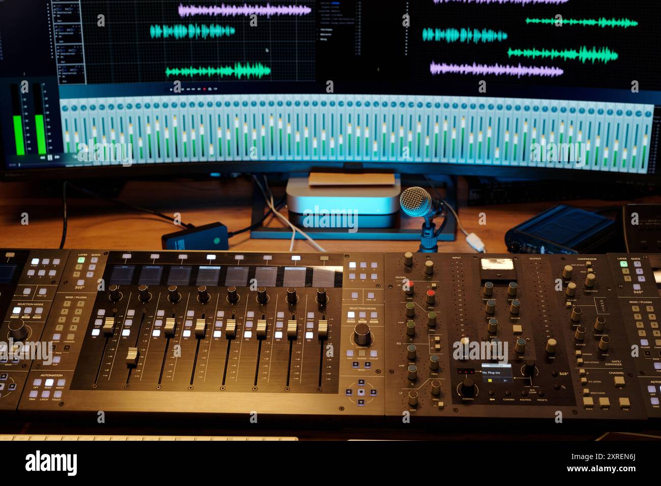 Audio mixing console, a microphone, and multiple screens displaying ...