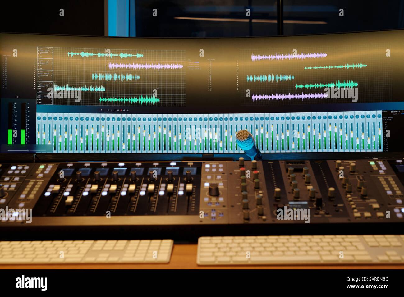 Professional mixing console in recording studio with large monitor ...