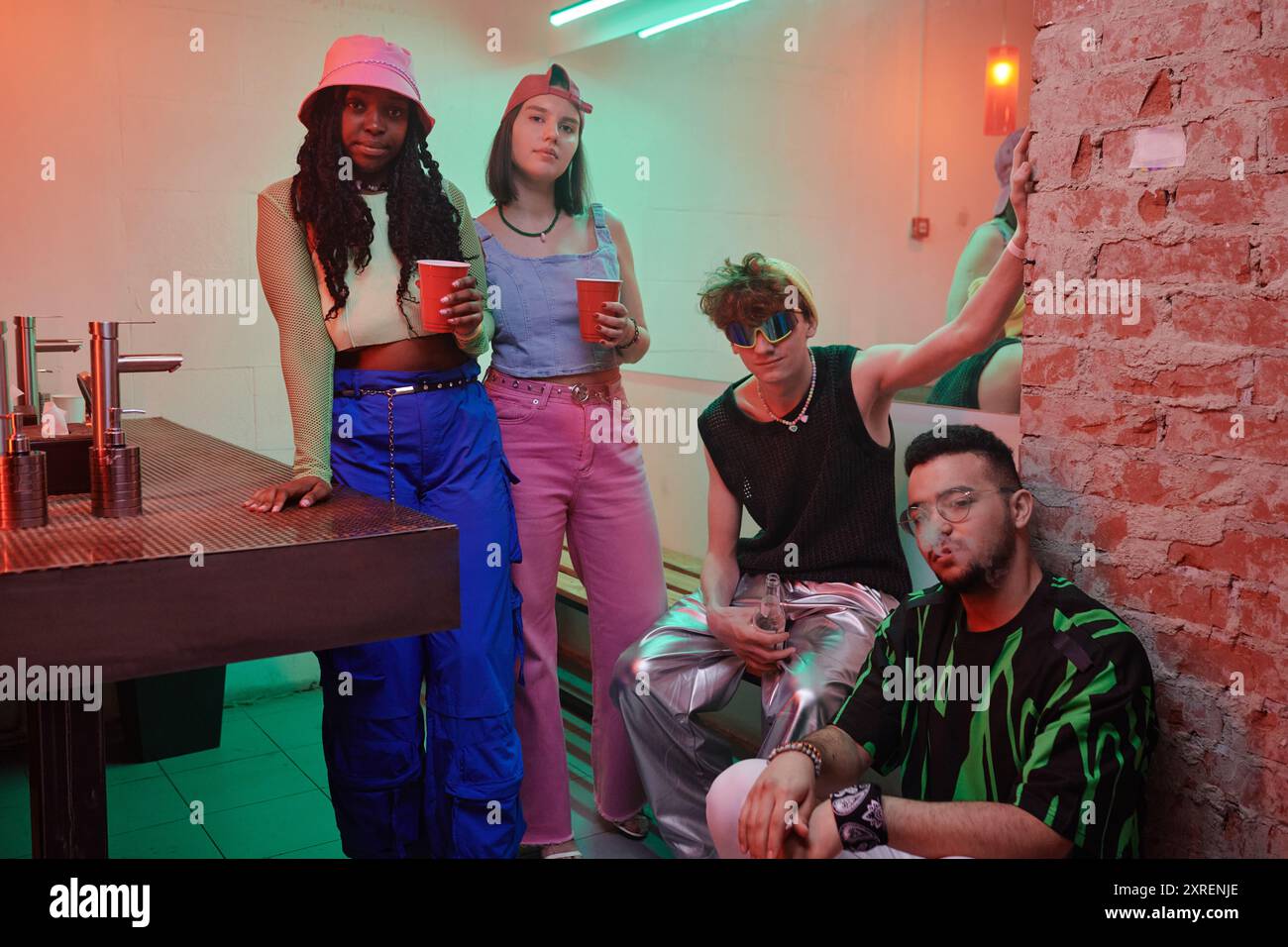 Group of young intercultural friends in funky attire looking at camera ...