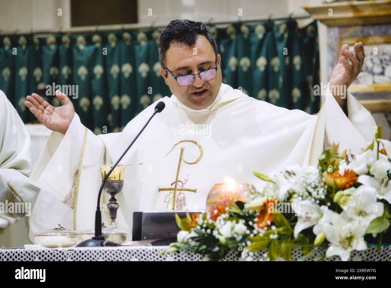 A white Caucasian catholic priest delivering Eucharistic prayer during ...