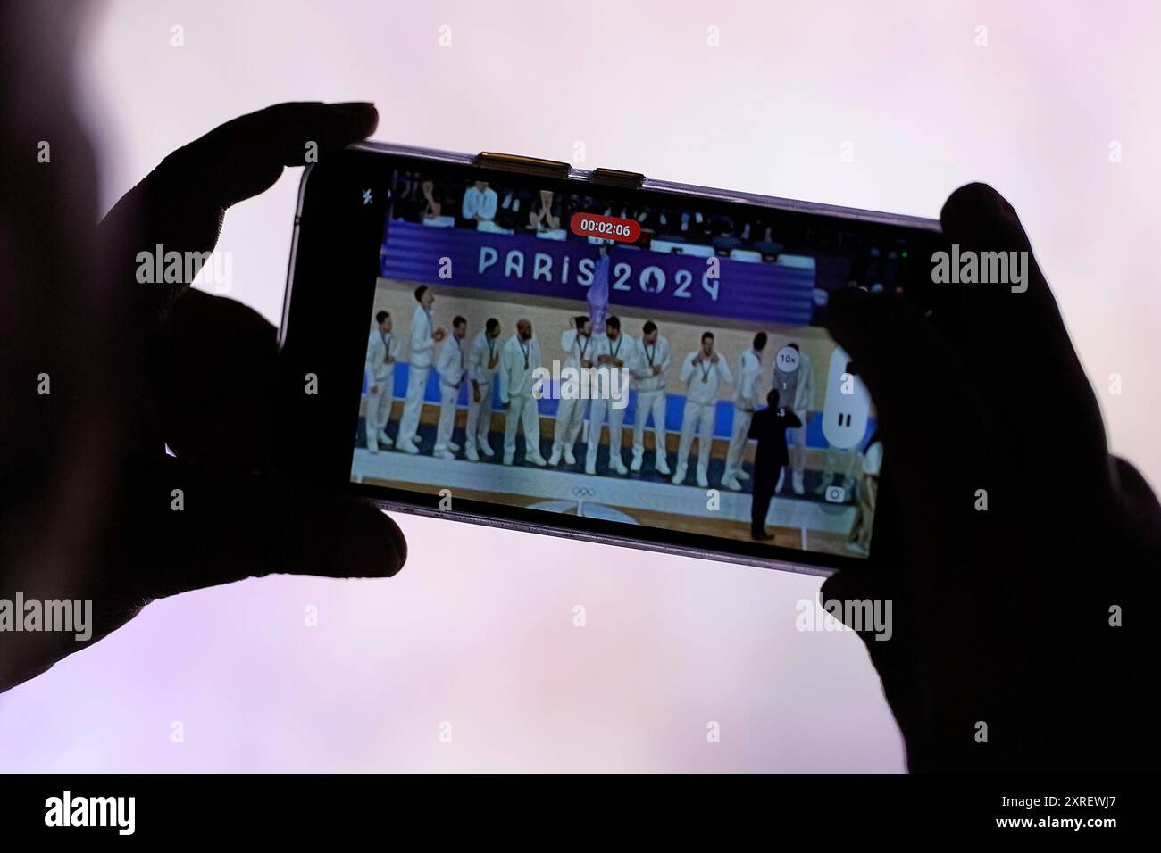 A man records the French volleyball team getting their gold medals ...