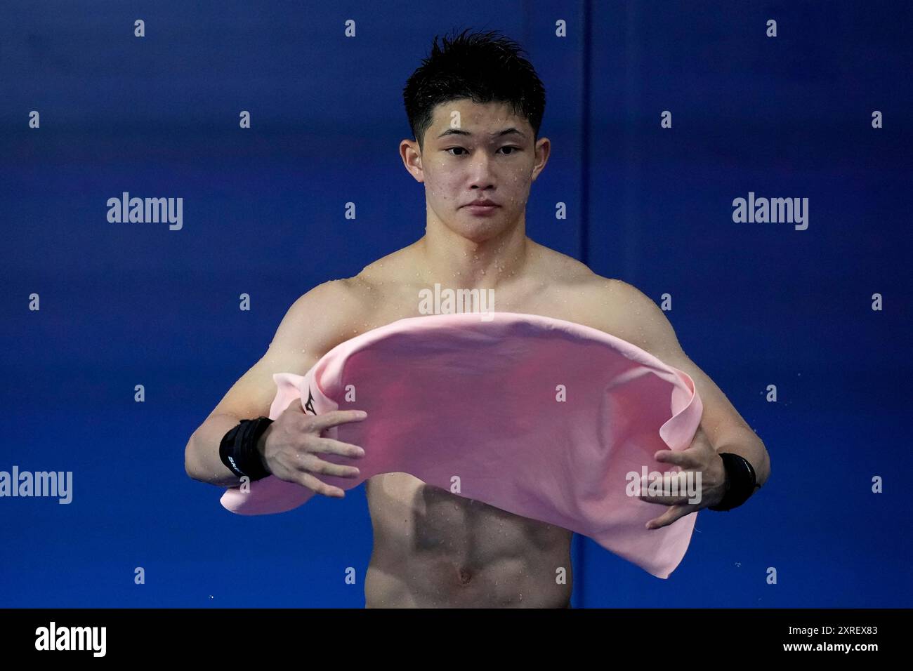 Japan's Rikuto Tamai uses his towel as he competes in the men's 10m ...