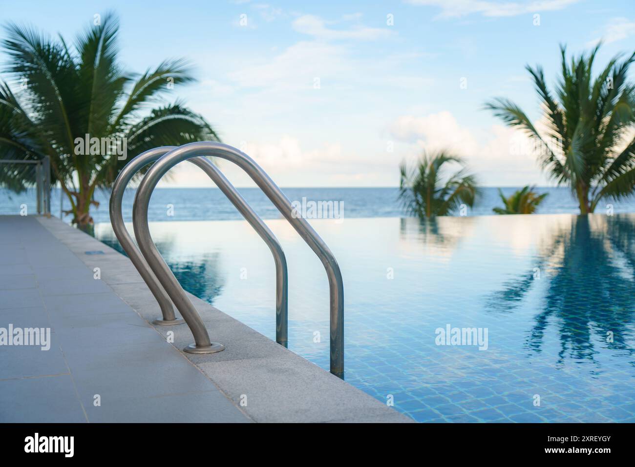 Swimming pool, with handrails for entry, on a sunny day Stock Photo - Alamy