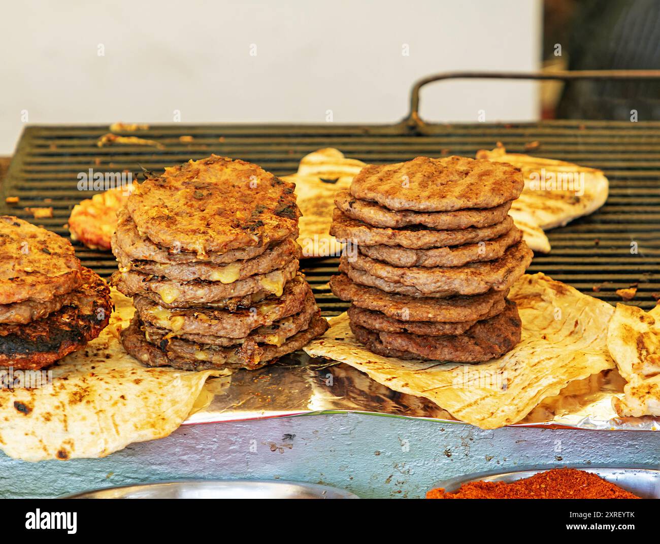 Stack of beef burgers on grill outside on market stall Stock Photo - Alamy