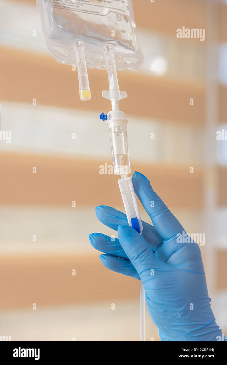 Nurse connecting an IV drip. Nurse preparing and regulating infusion ...