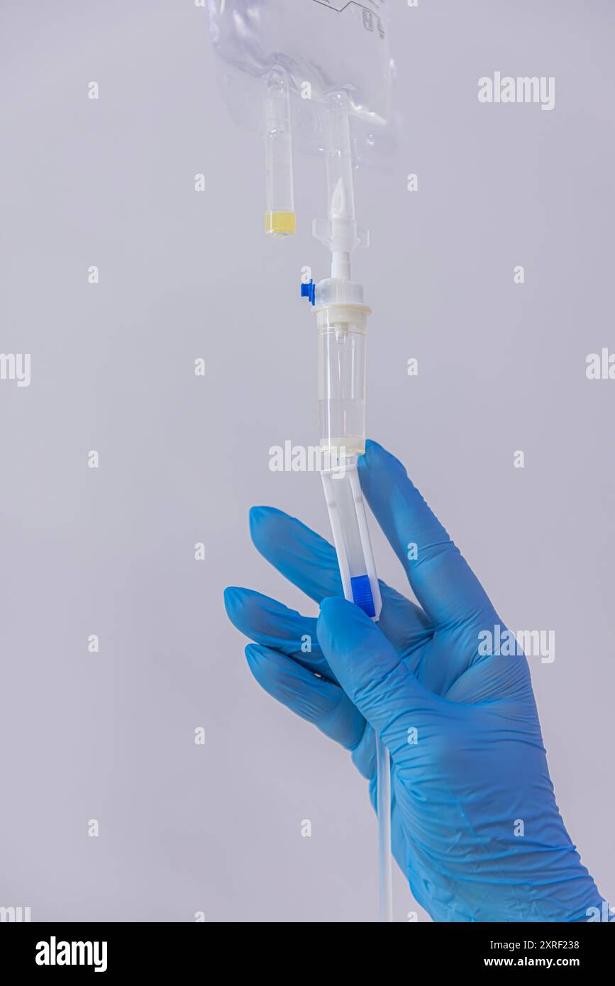 Nurse connecting an IV drip. Nurse preparing and regulating infusion for patient in hospital ...