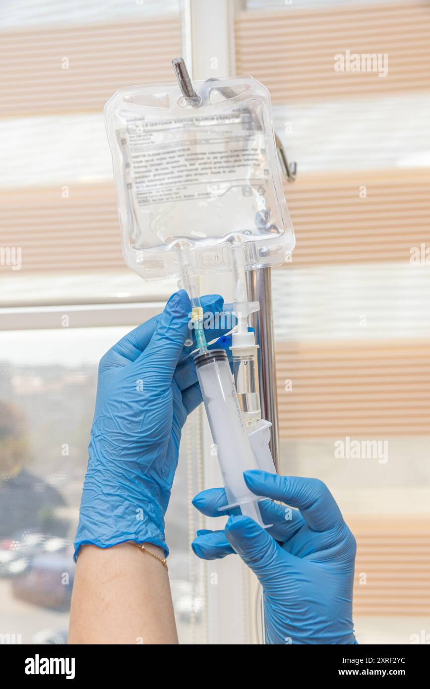 Nurse connecting an IV drip. Nurse preparing and regulating infusion ...