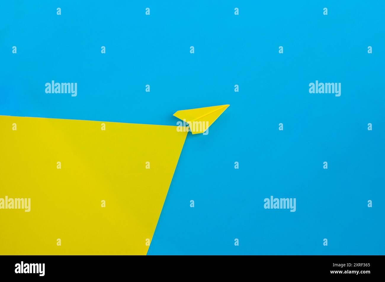 Angle view of yellow paper airplane flying along the route on blue ...