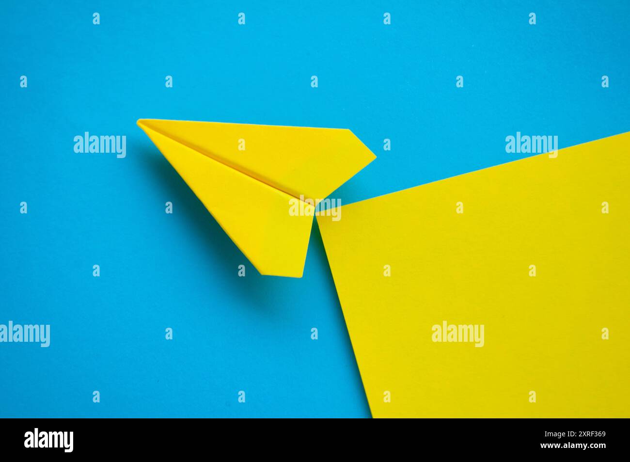 Top view of yellow paper airplane flying along the route on blue ...