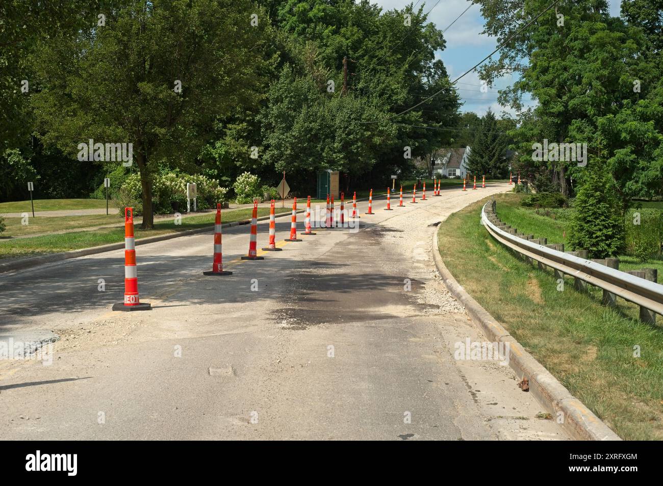 Orange and white traffic cones mark off a lane of a city street that is ...