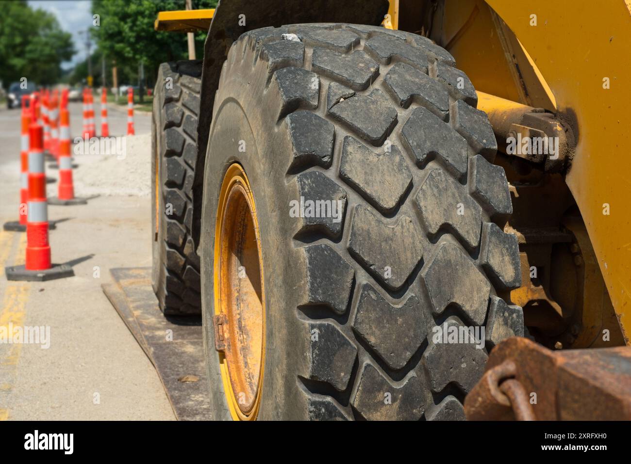 Big wheels on a front loader sitting idle in a road construction ...