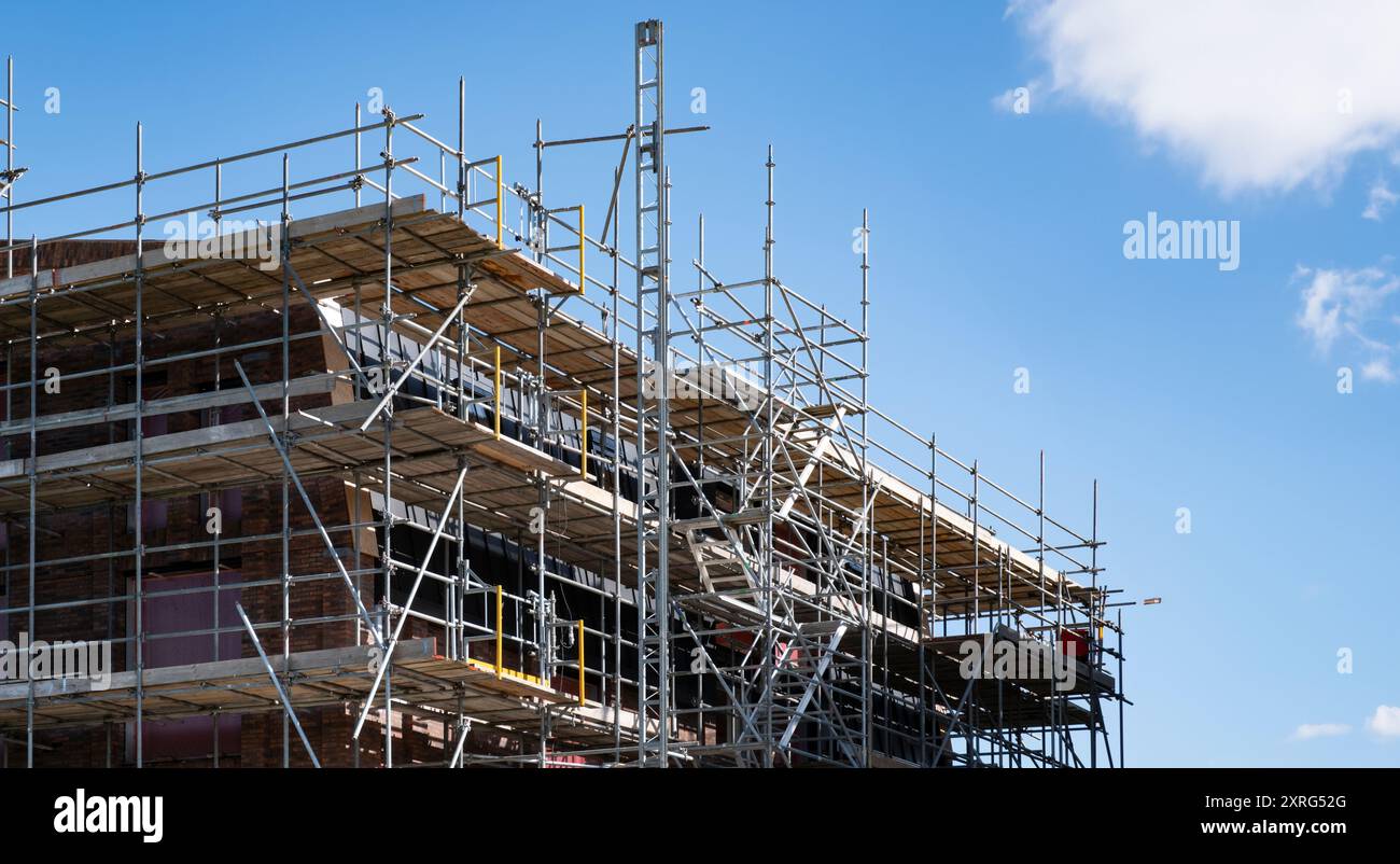 Scaffolding with platforms against a high-rise new-build apartment ...