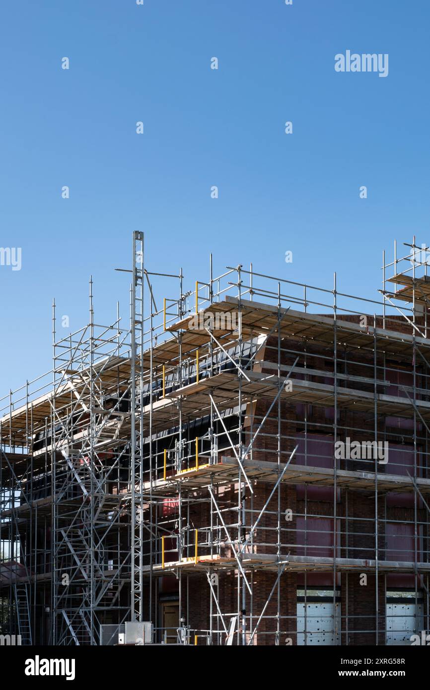 Scaffolding with platforms against a high-rise new-build apartment ...