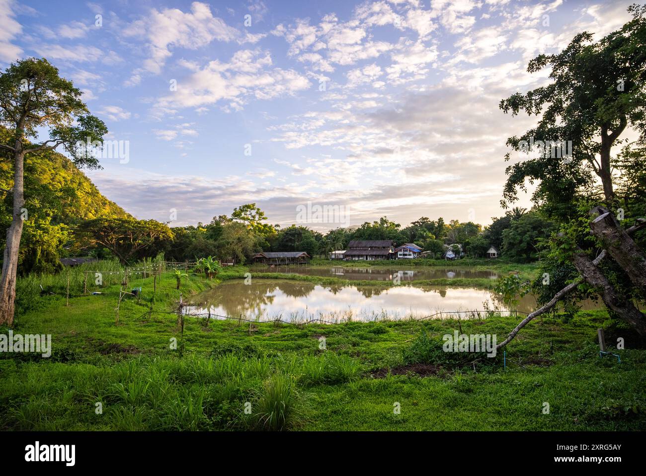 Wooden traditional house by a pond at sunset in Chiang Rai, north of ...