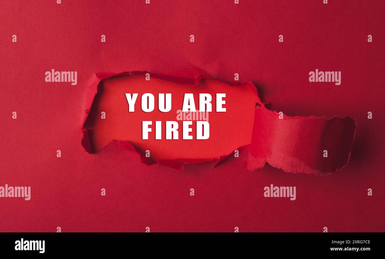 A red background with a hole in it and the words You are fired written ...