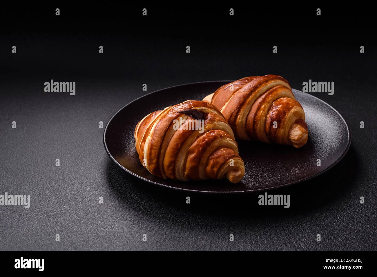 Delicious crispy sweet croissant cornet with chocolate on a dark ...