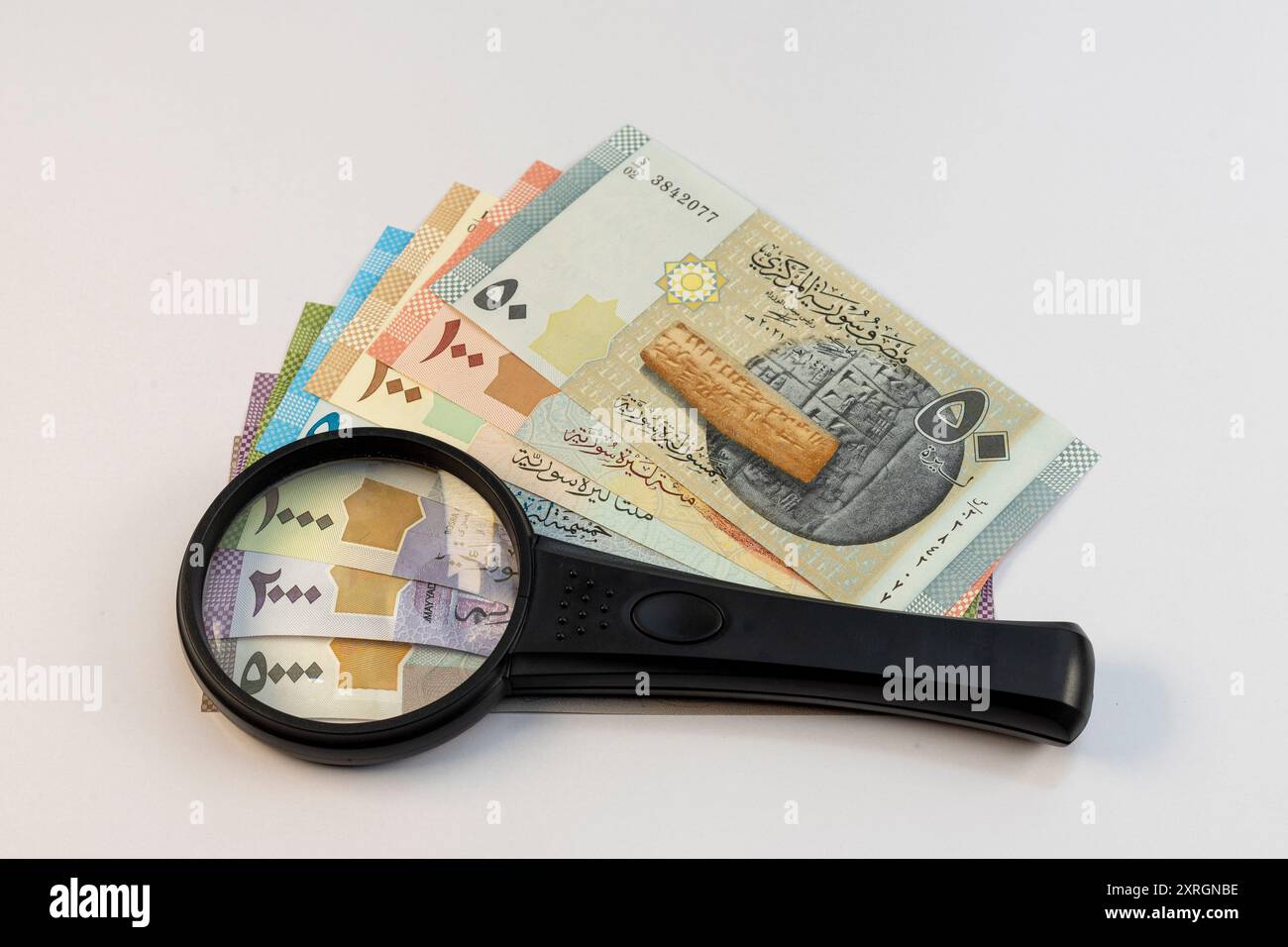 Syria currency banknotes with magnifying glass isolated on white ...