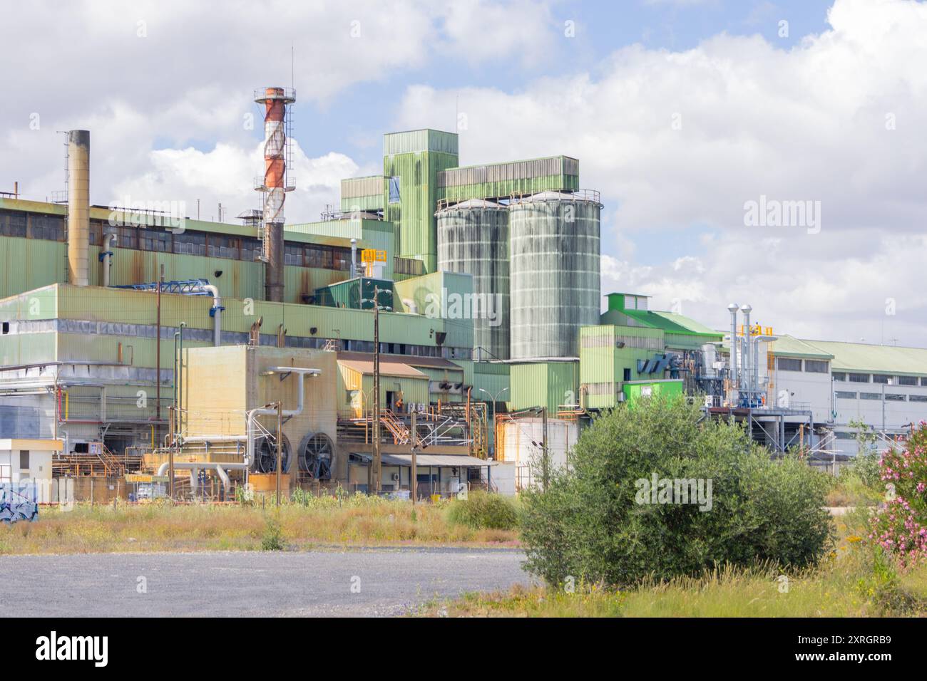 Exterior view of a large sugar refinery processing plant with machinery ...