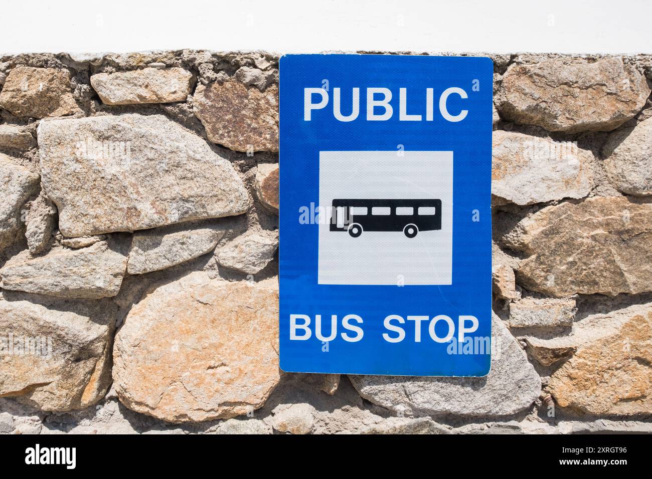 Public bus stop sign on a stone wall Stock Photo - Alamy