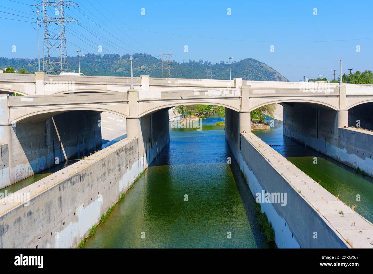 View of Los Angeles River flowing beneath a bridge, featuring concrete ...