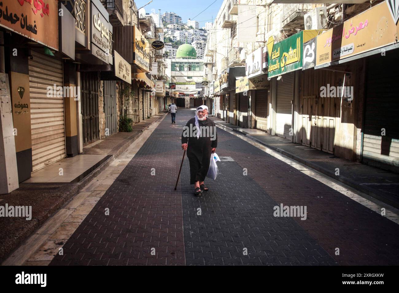 Palestinian walks through a deserted commercial area in Nablus in the ...