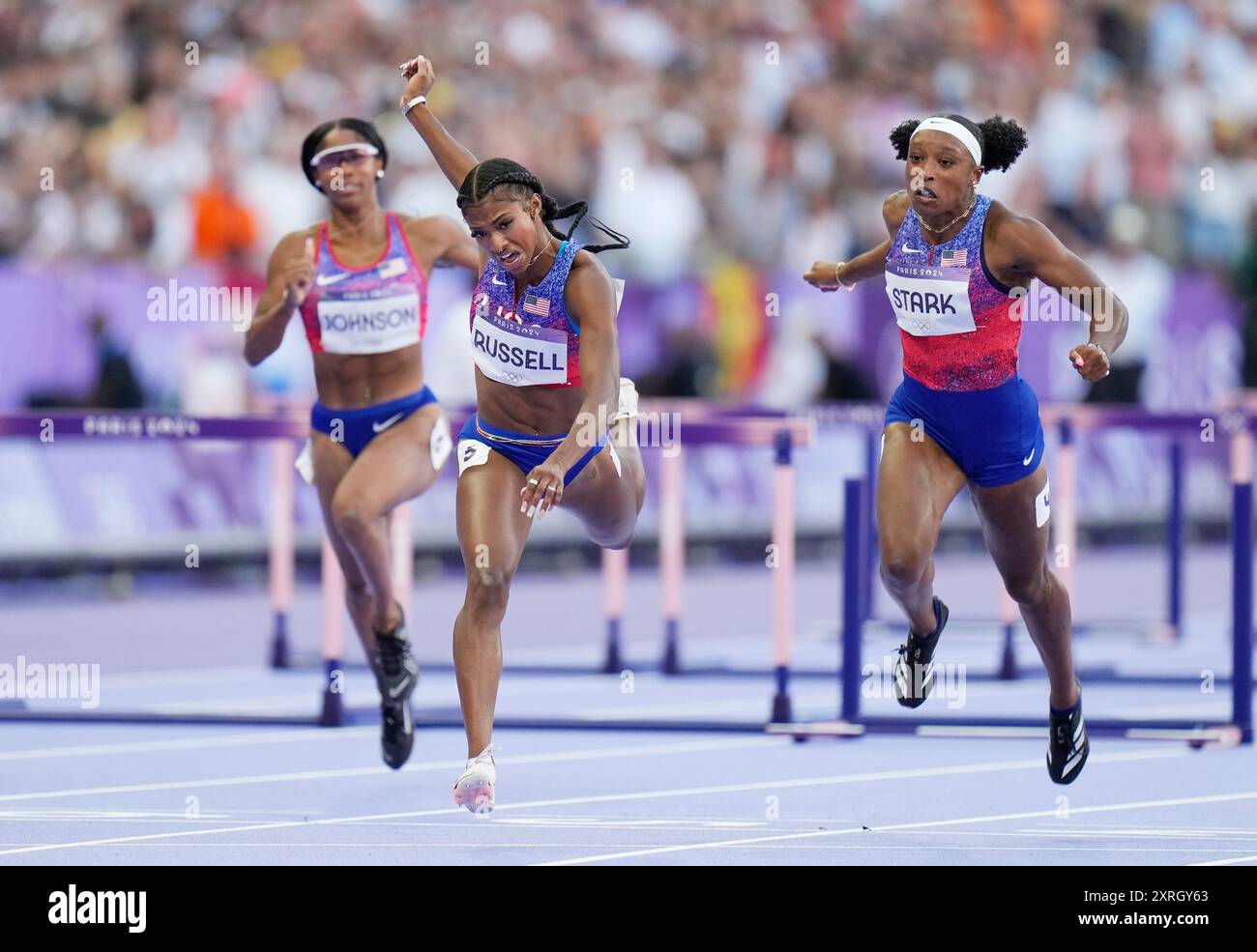 Masai Russell of the U.S. (C) crosses the finish line to win the gold ...