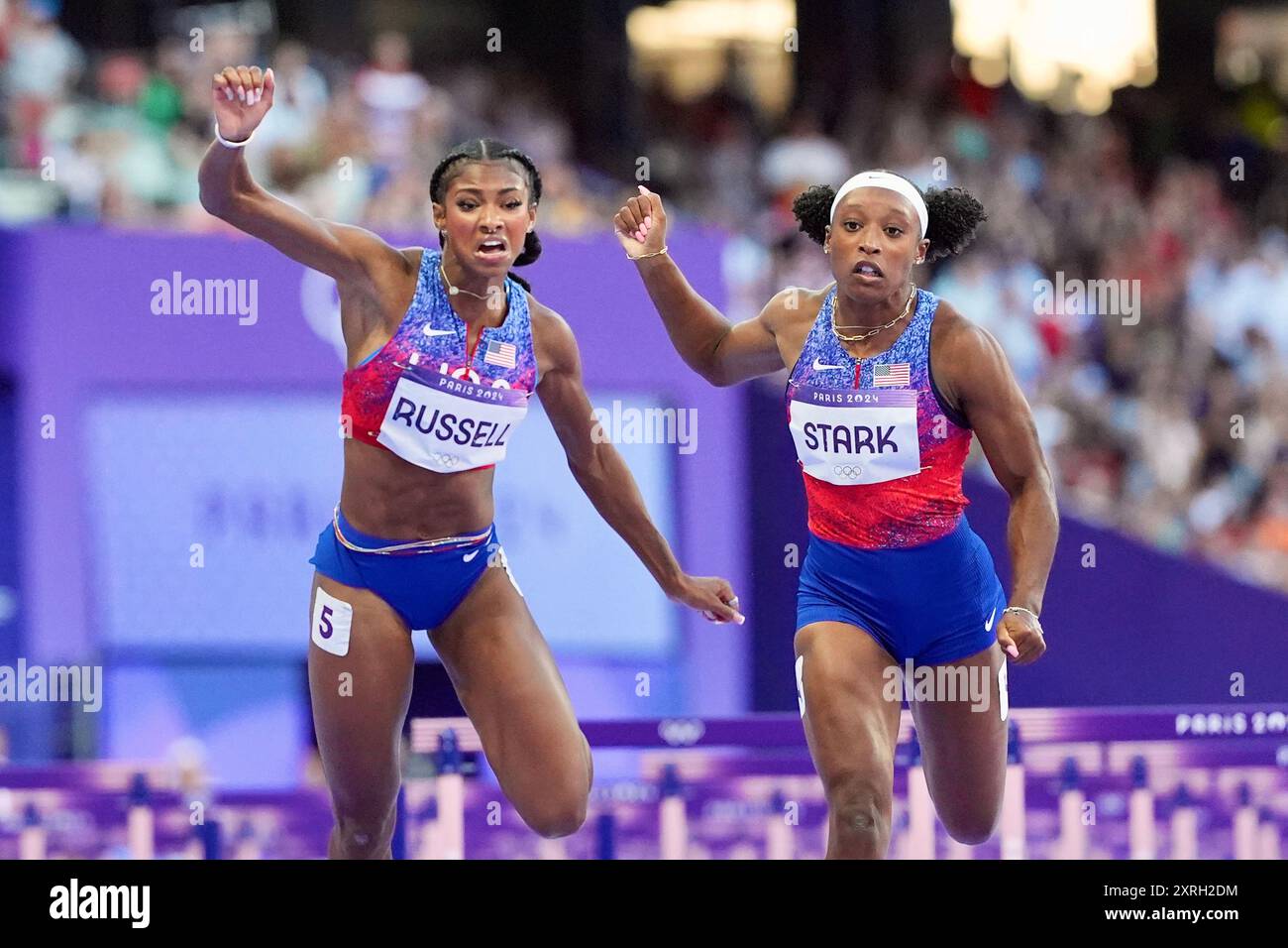 Masai Russell of the U.S. (L) crosses the finish line ahead of Grace ...
