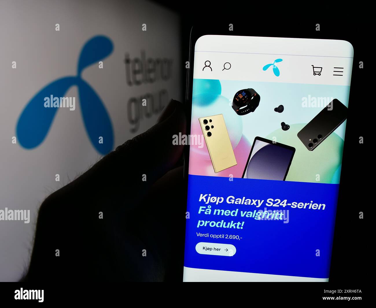 Person holding smartphone with webpage of Norwegian telecommunications ...