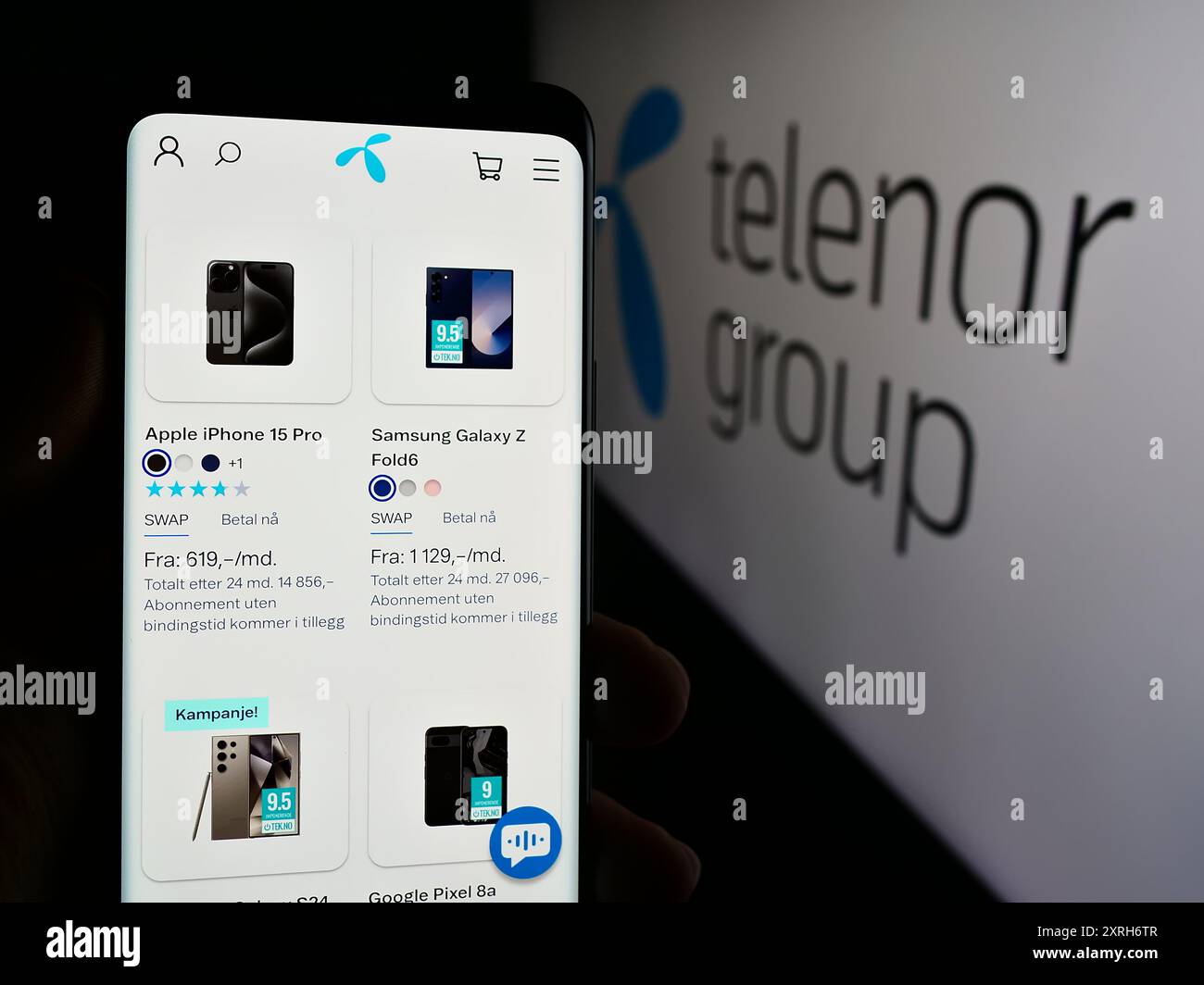 Person holding cellphone with webpage of Norwegian telecommunications company Telenor ASA in ...
