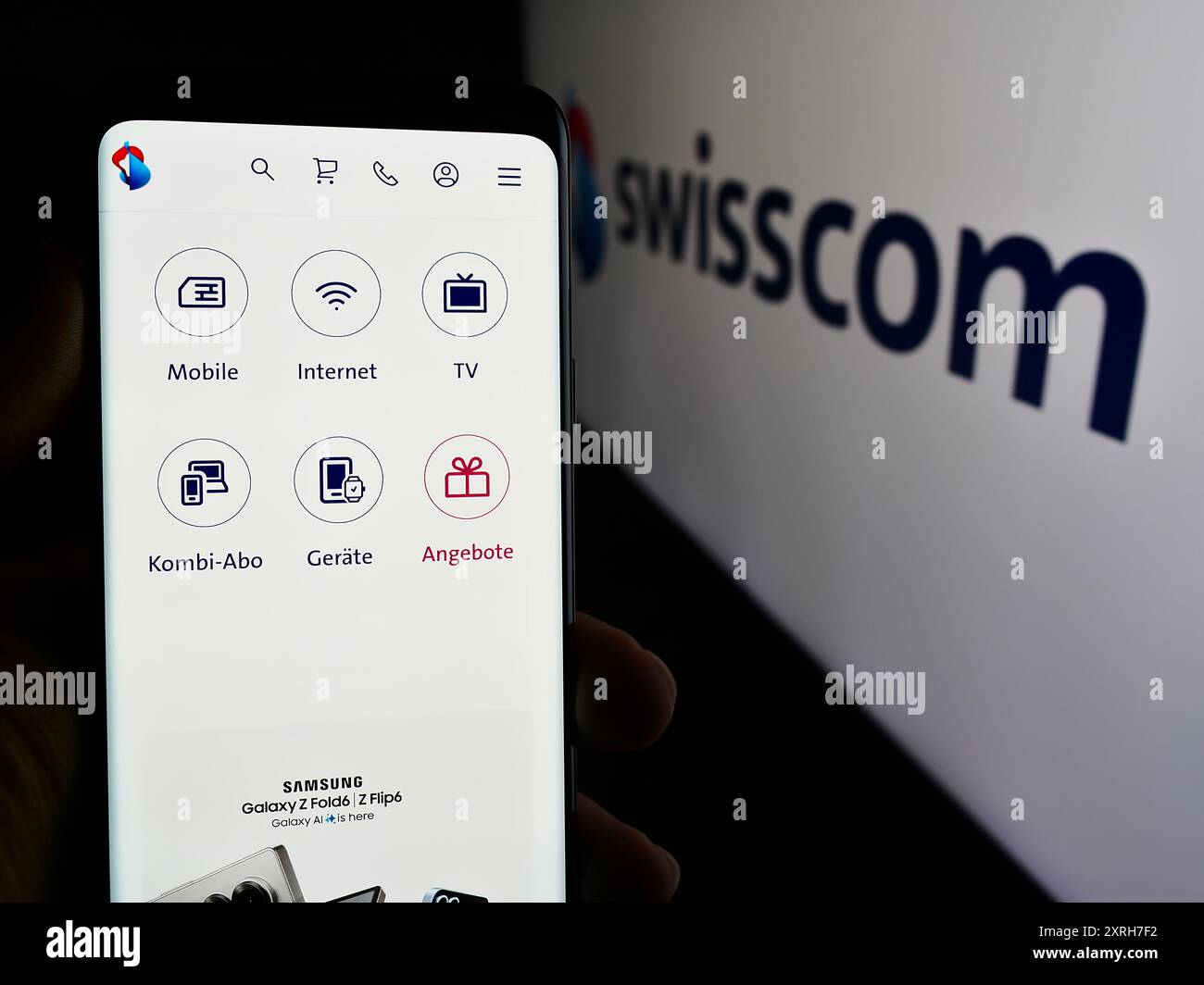 Person holding mobile phone with web page of Swiss telecommunications ...