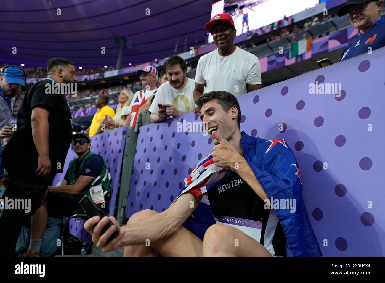 Hamish Kerr, of New Zealand, uses a cellphone while sitting by the ...