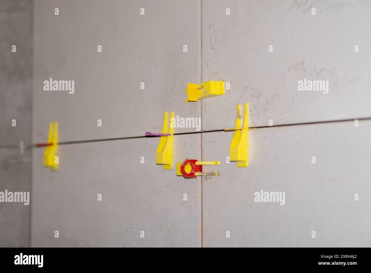 Tile installation using plastic leveling clips and wedges. Ensuring a ...