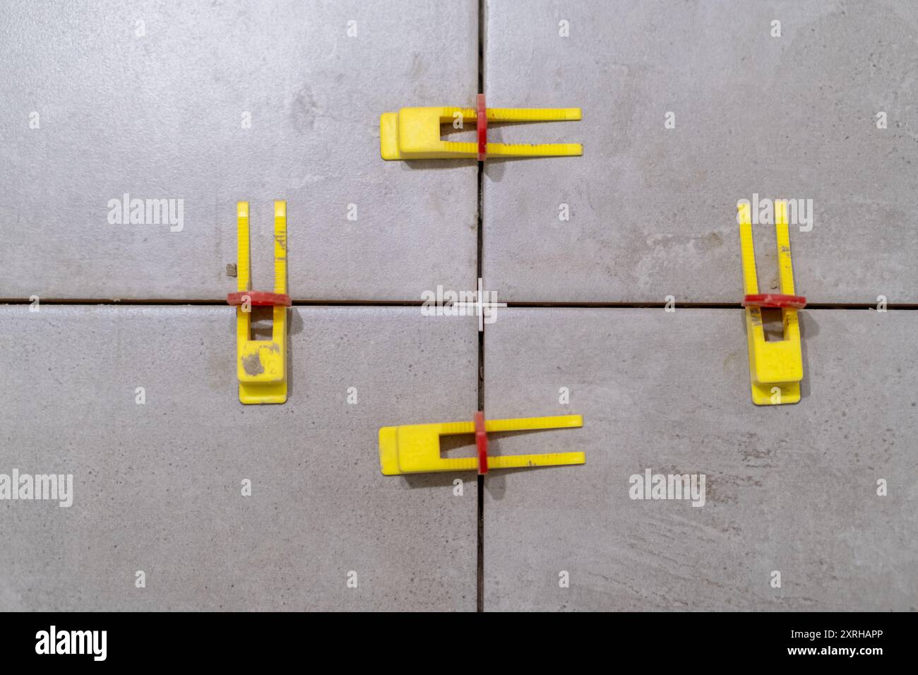 Plastic clips and wedges securing tiles in place for perfect alignment ...