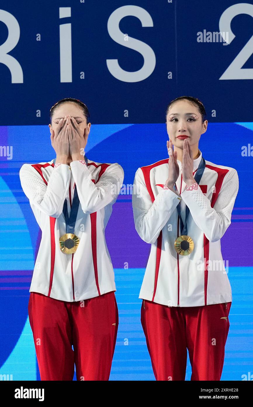 China's Wang Liuyi and Wang Qianyi, react with their national flag ...