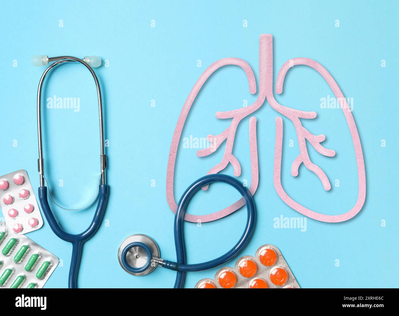 Stethoscope, drugs and illustration of lungs on light blue background ...