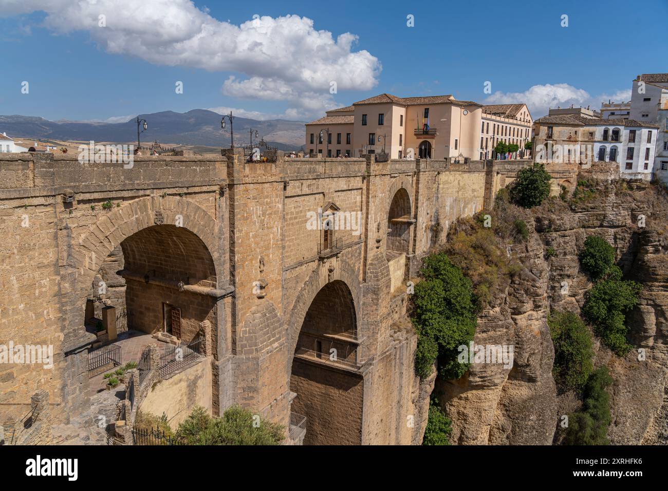 The iconic Puente Nuevo Bridge in Ronda, Spain, gracefully arches over the deep Tajo Gorge, with ...