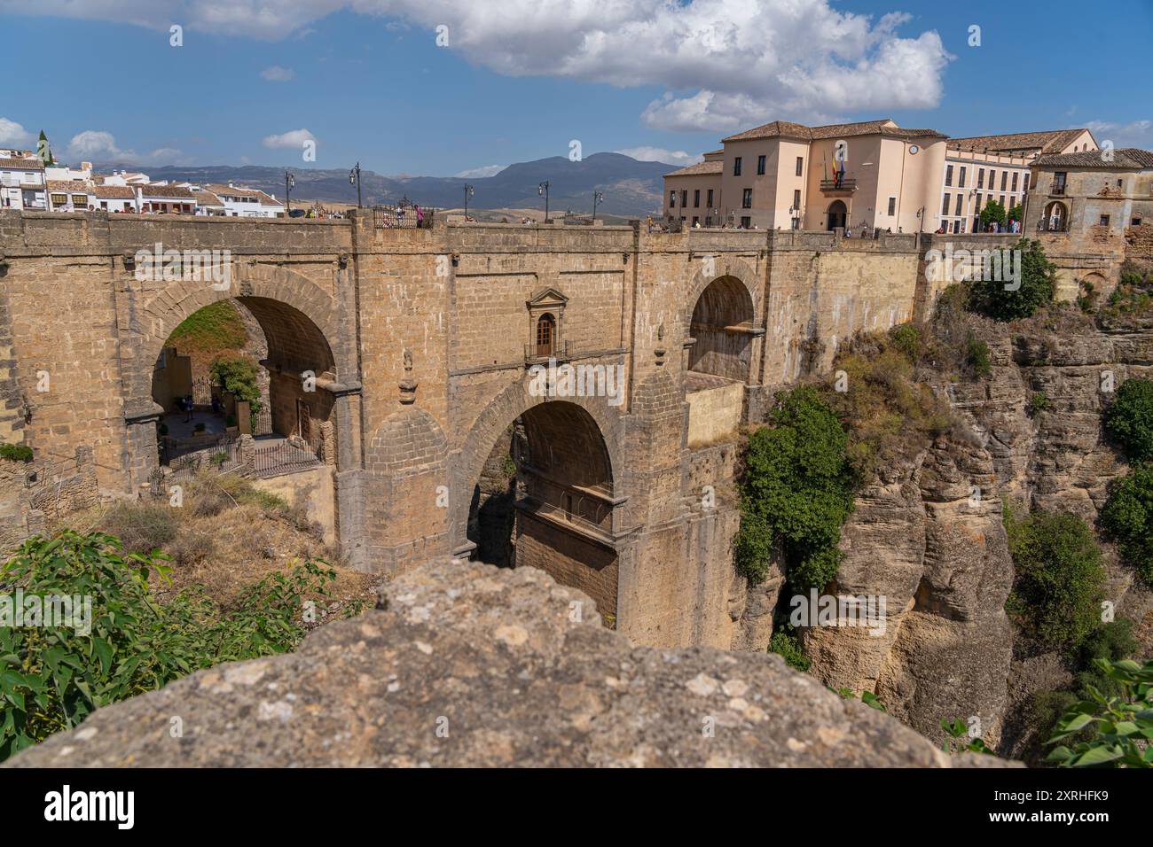 The iconic Puente Nuevo Bridge in Ronda, Spain, gracefully arches over the deep Tajo Gorge, with ...