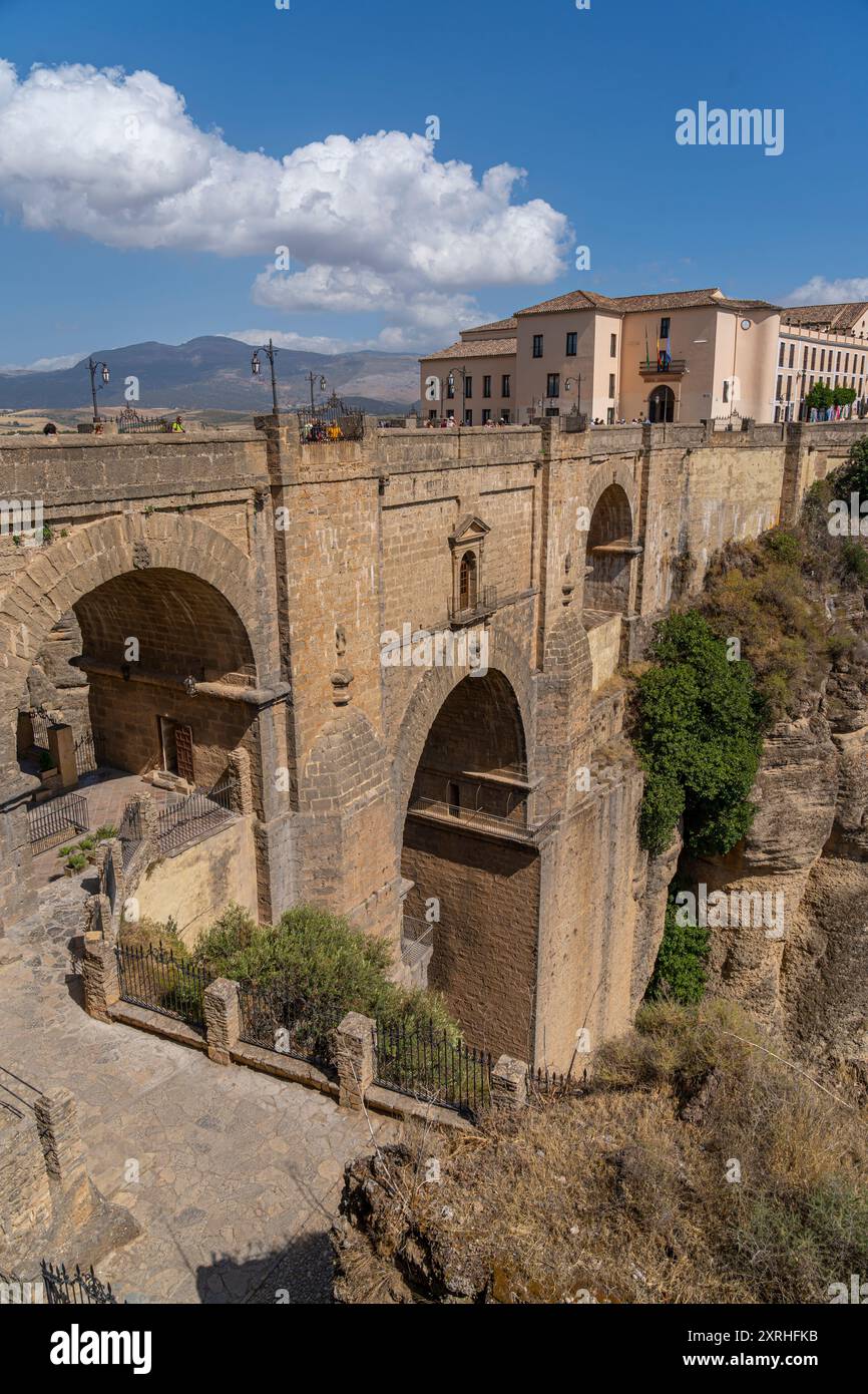 The iconic Puente Nuevo Bridge in Ronda, Spain, gracefully arches over the deep Tajo Gorge, with ...